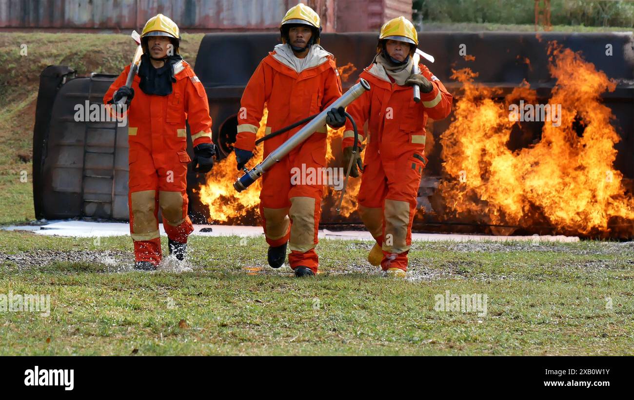 Firefighter fighting with flame using fire hose chemical water foam ...