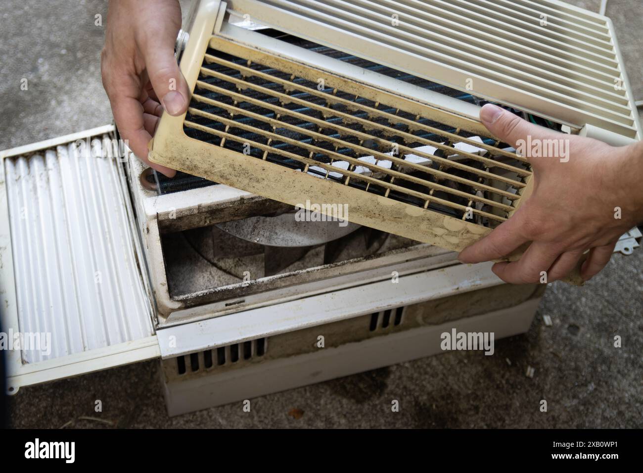Removing cover from window air conditioner to clean and service unit ...