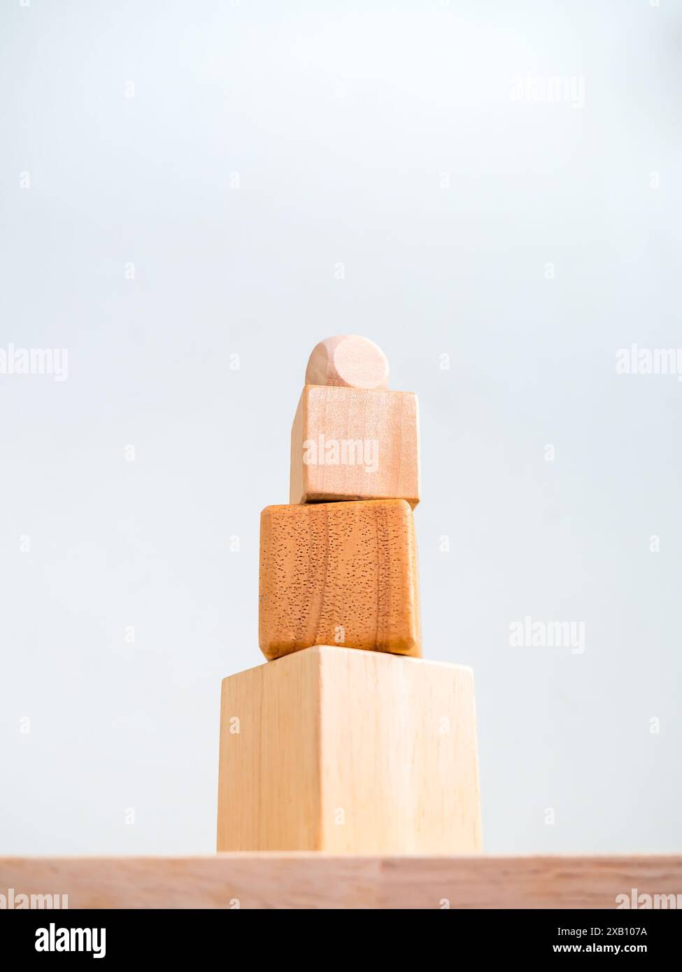 Four empty wooden cube blocks stack from small to large size on table ...