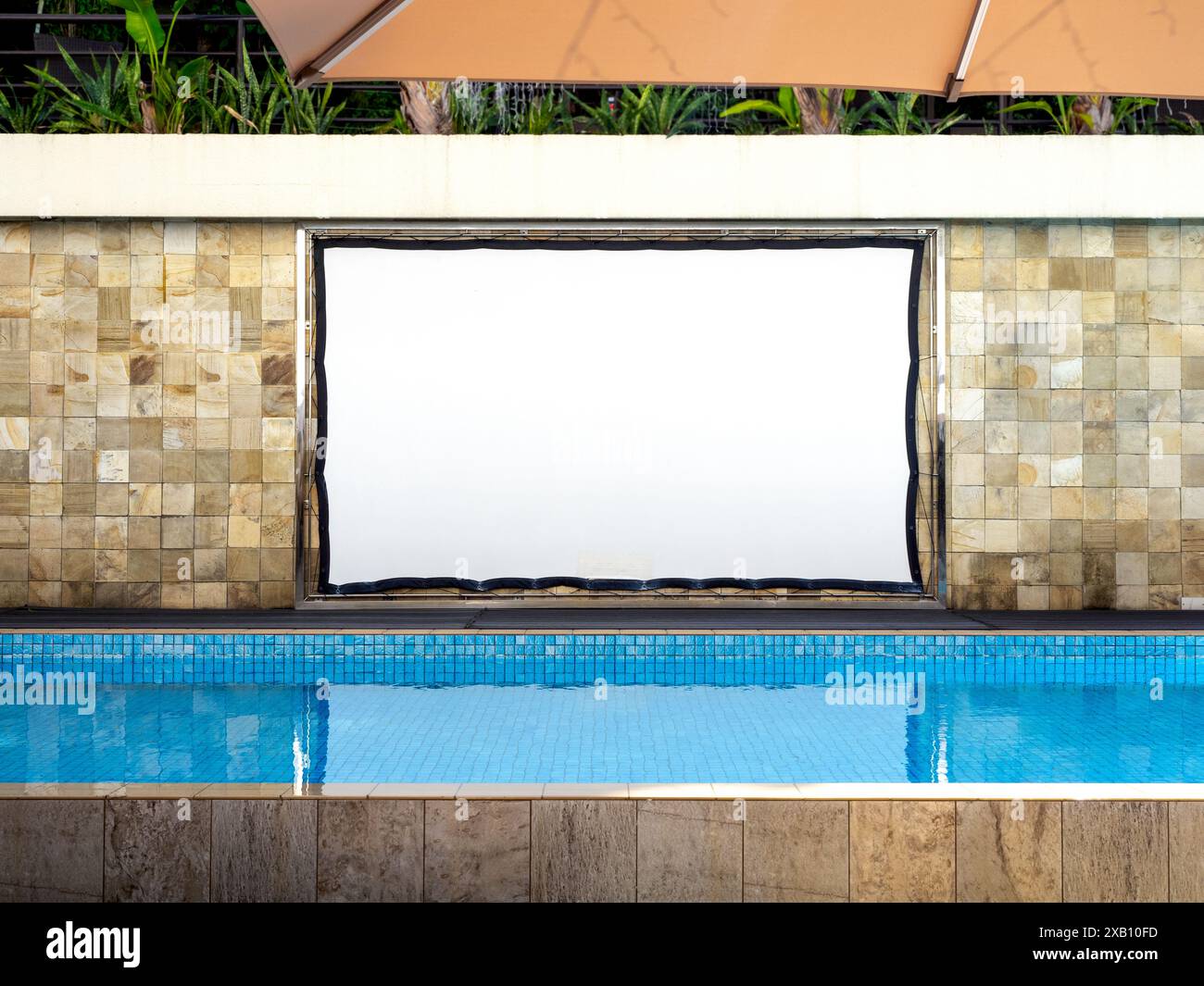 Blank white large outdoor waterproof projector screen hanging on tiles wall background near the ...