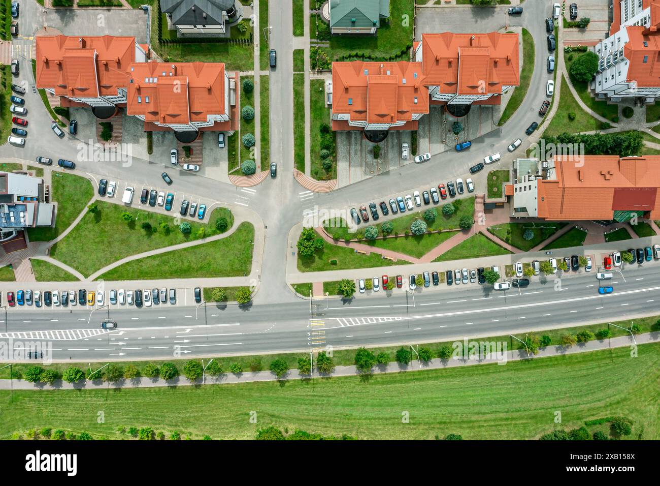 neighborhood in the suburban area with homes, streets and parked cars ...