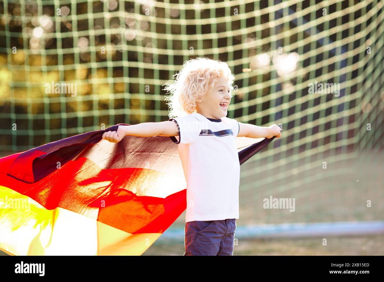Kids play football on outdoor field. Germany team fans with national ...