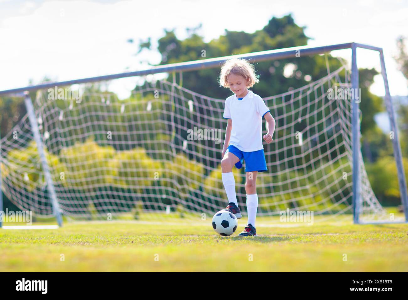 Kids play football on outdoor field. England team fan. Children score a ...