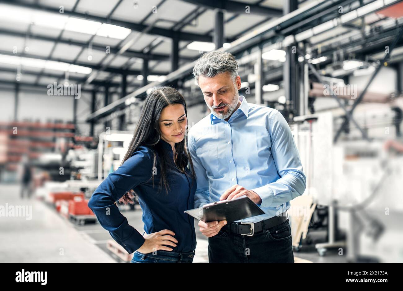 Two project managers standing in modern industrial factory ...