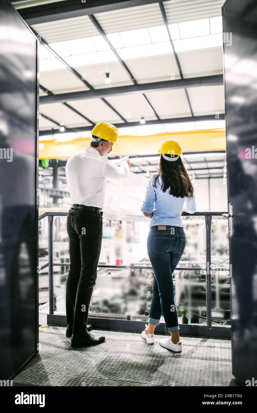 Two project managers standing in modern industrial factory ...