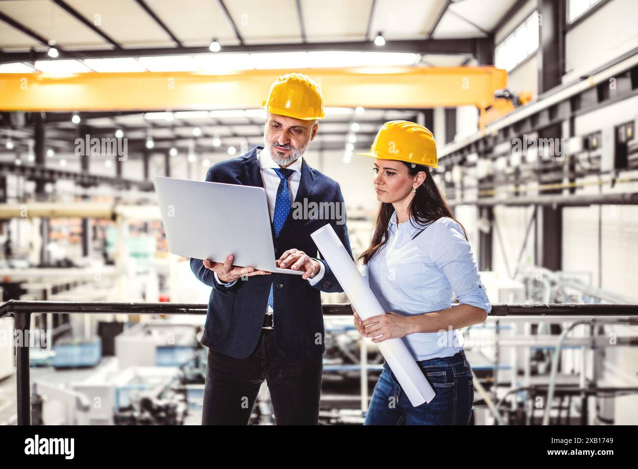Two project managers standing in modern industrial factory ...