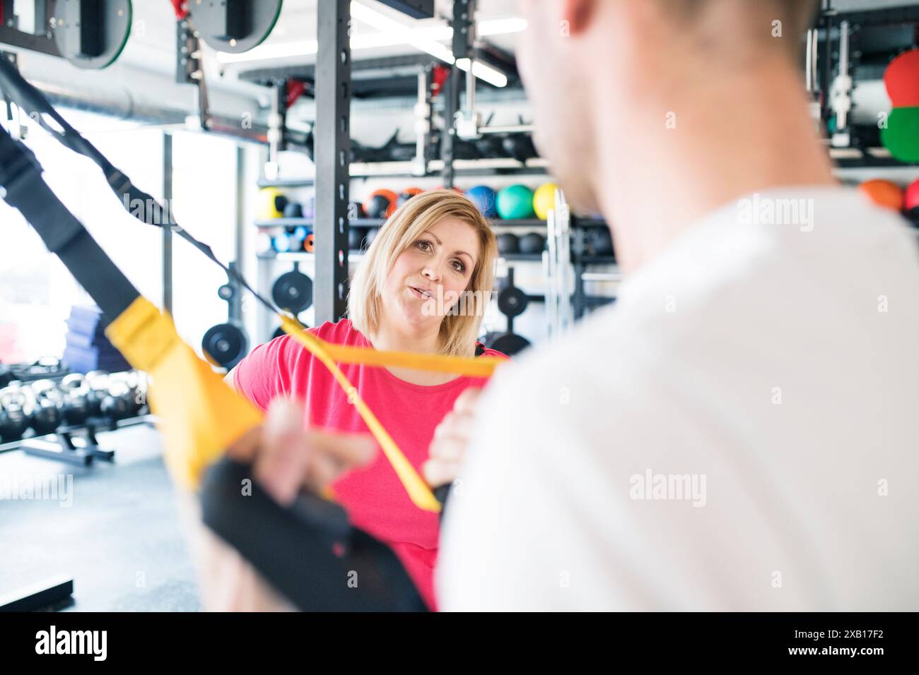 Overweight woman exercising in gym, doing suspension training, total ...