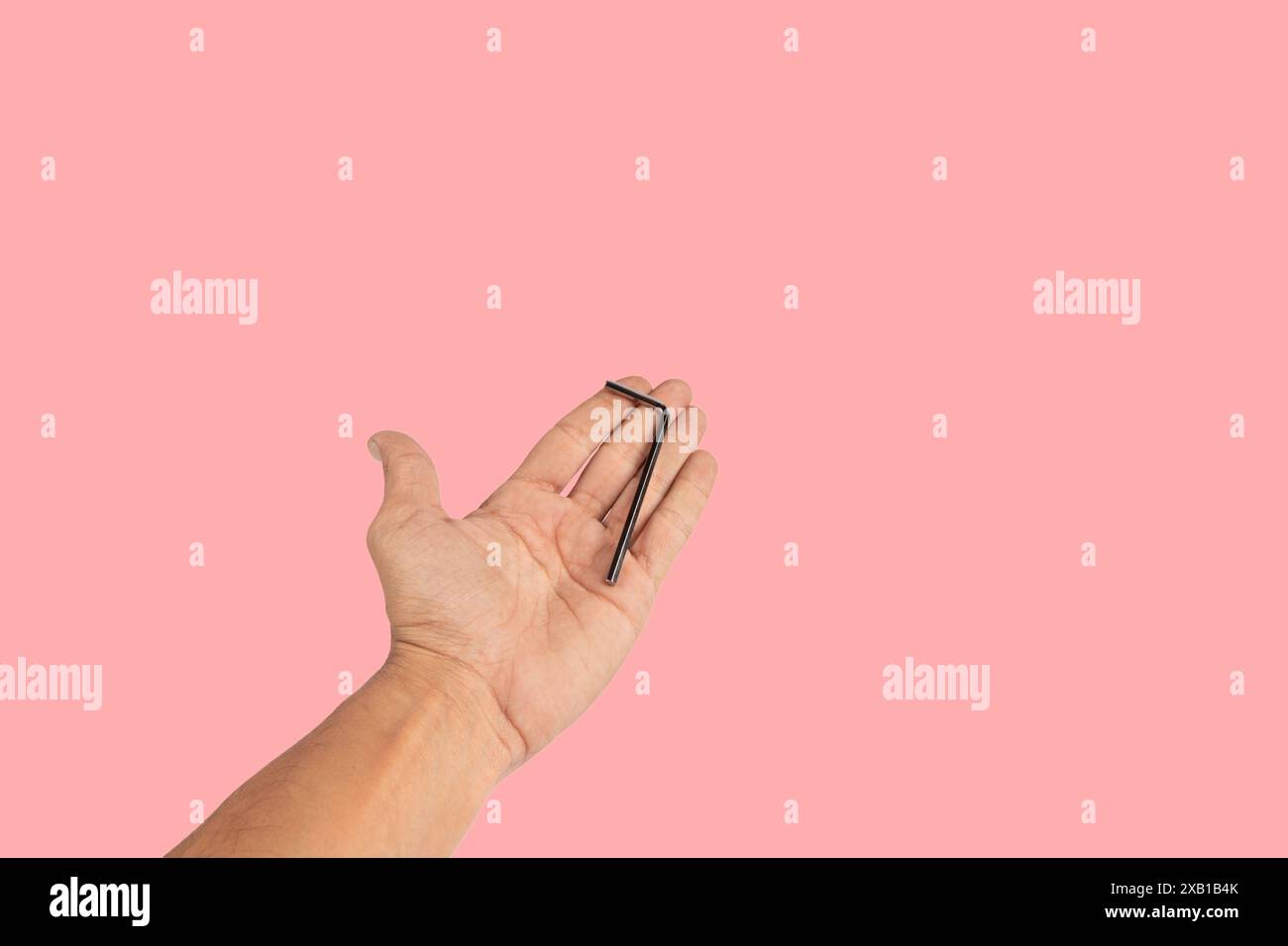 Black male hand offering an allen key isolated on pink background Stock ...