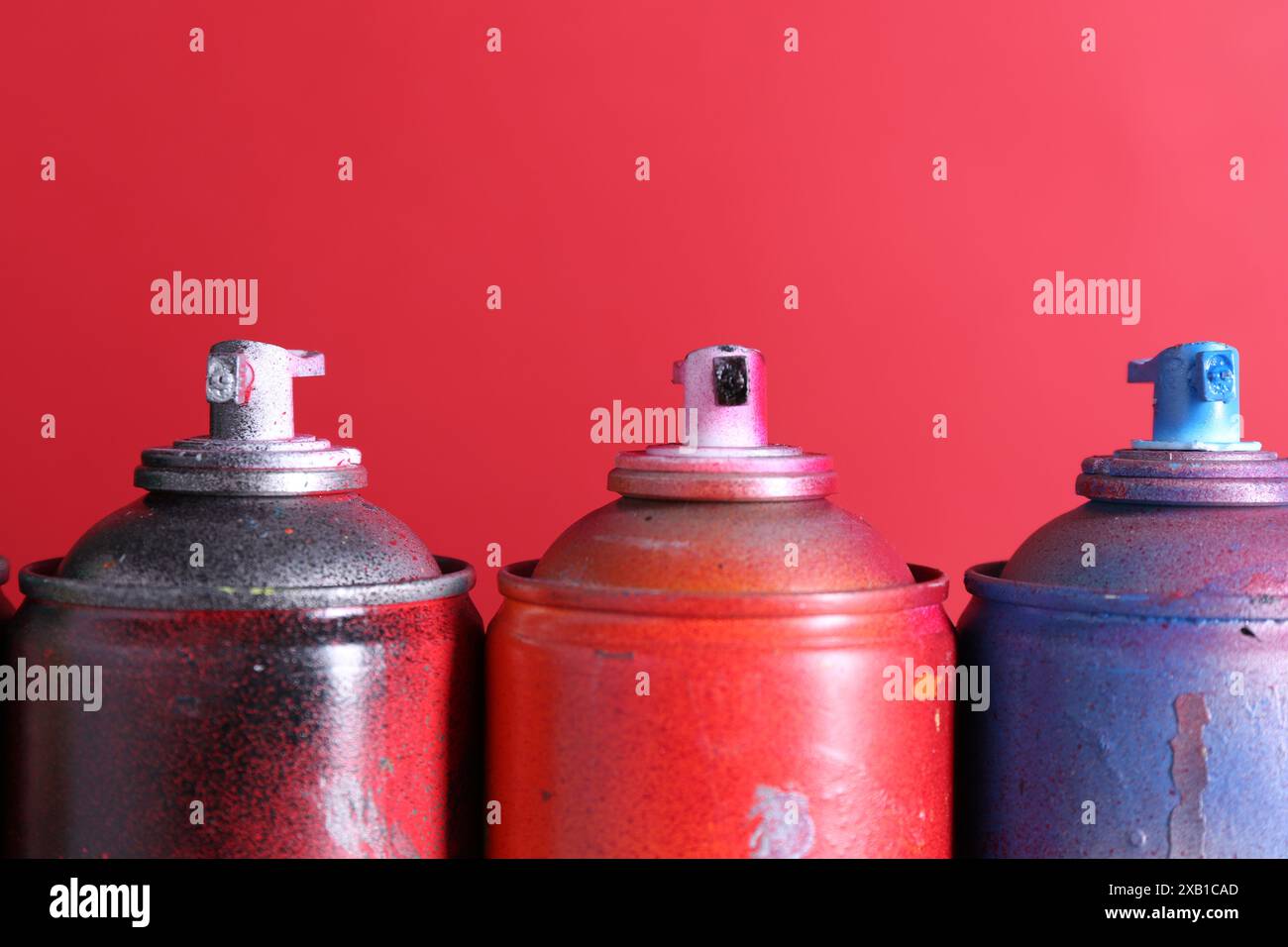 Many spray paint cans on red background, closeup. Space for text Stock ...