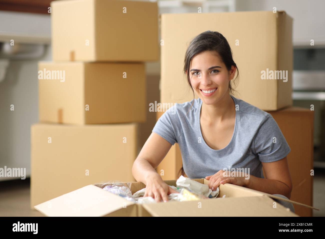 Happy homeowner moving house posing looking at camera Stock Photo - Alamy