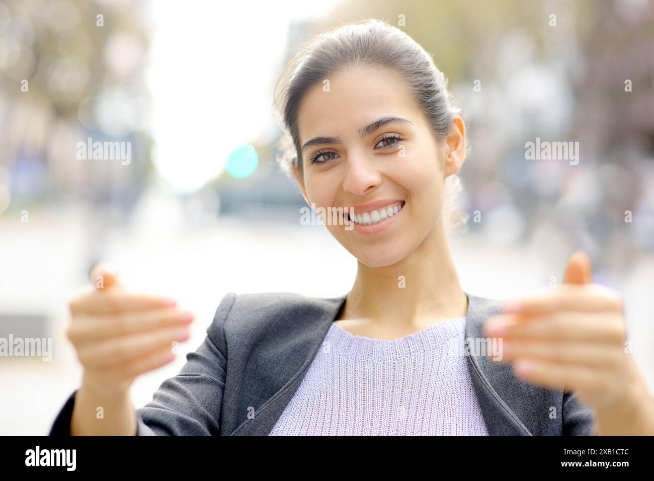 Front view portrait of a happy young executive saying follow me ...