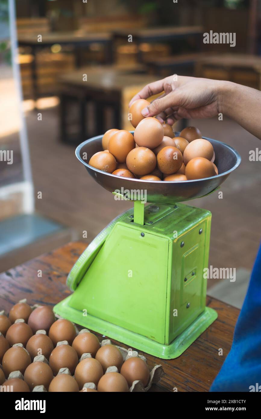 stack of chicken eggs being weight by merchant Stock Photo - Alamy