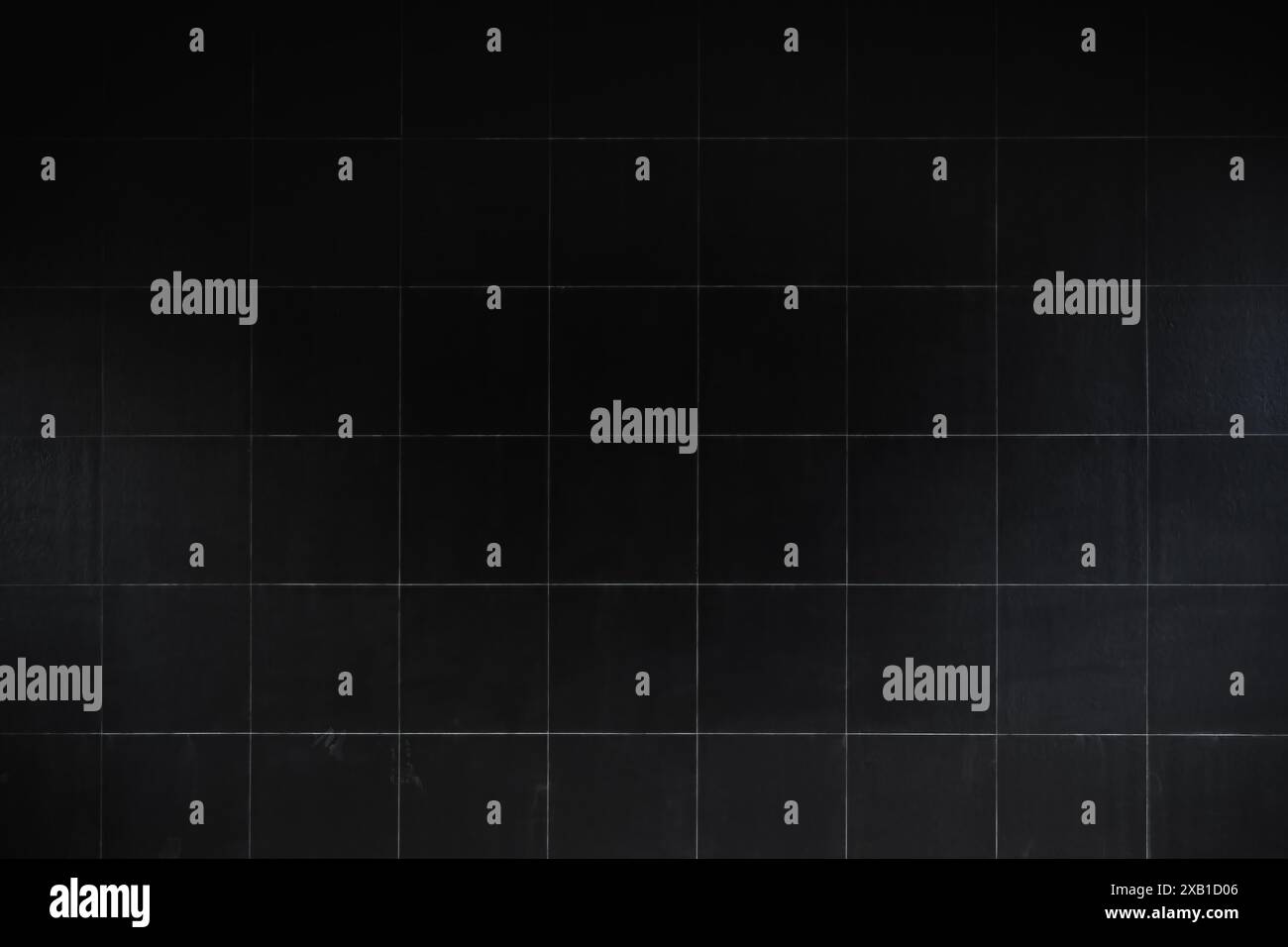 Old dirty black square-shaped ceramic tiles on the wall as background ...