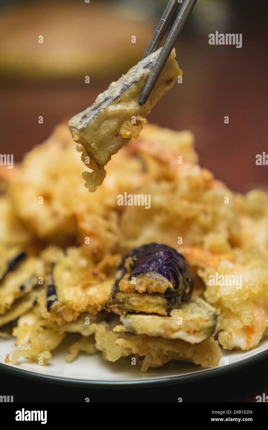 fried eggplant coated in flour, with a chopstick picking, close up and ...