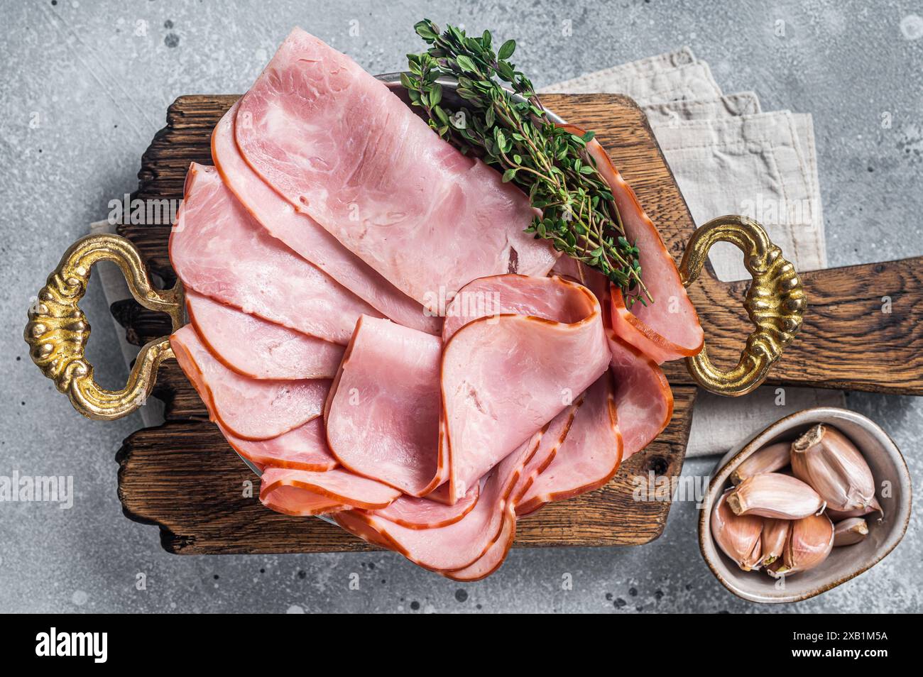 Slices of square sandwich ham with herbs in skillet. Gray background ...