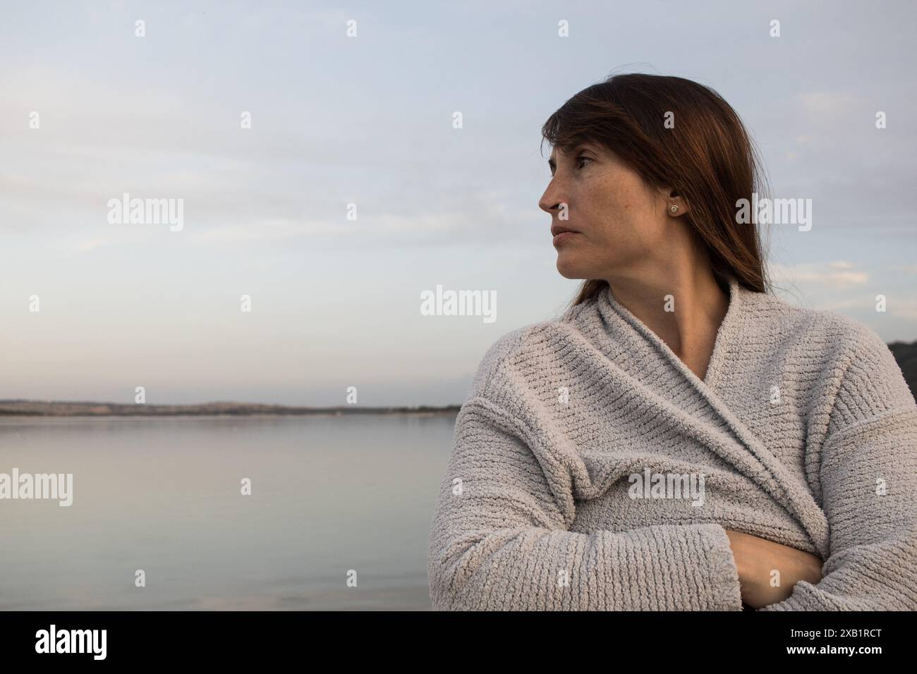 woman looking calm and relaxed towards, horizon alone on the coast ...