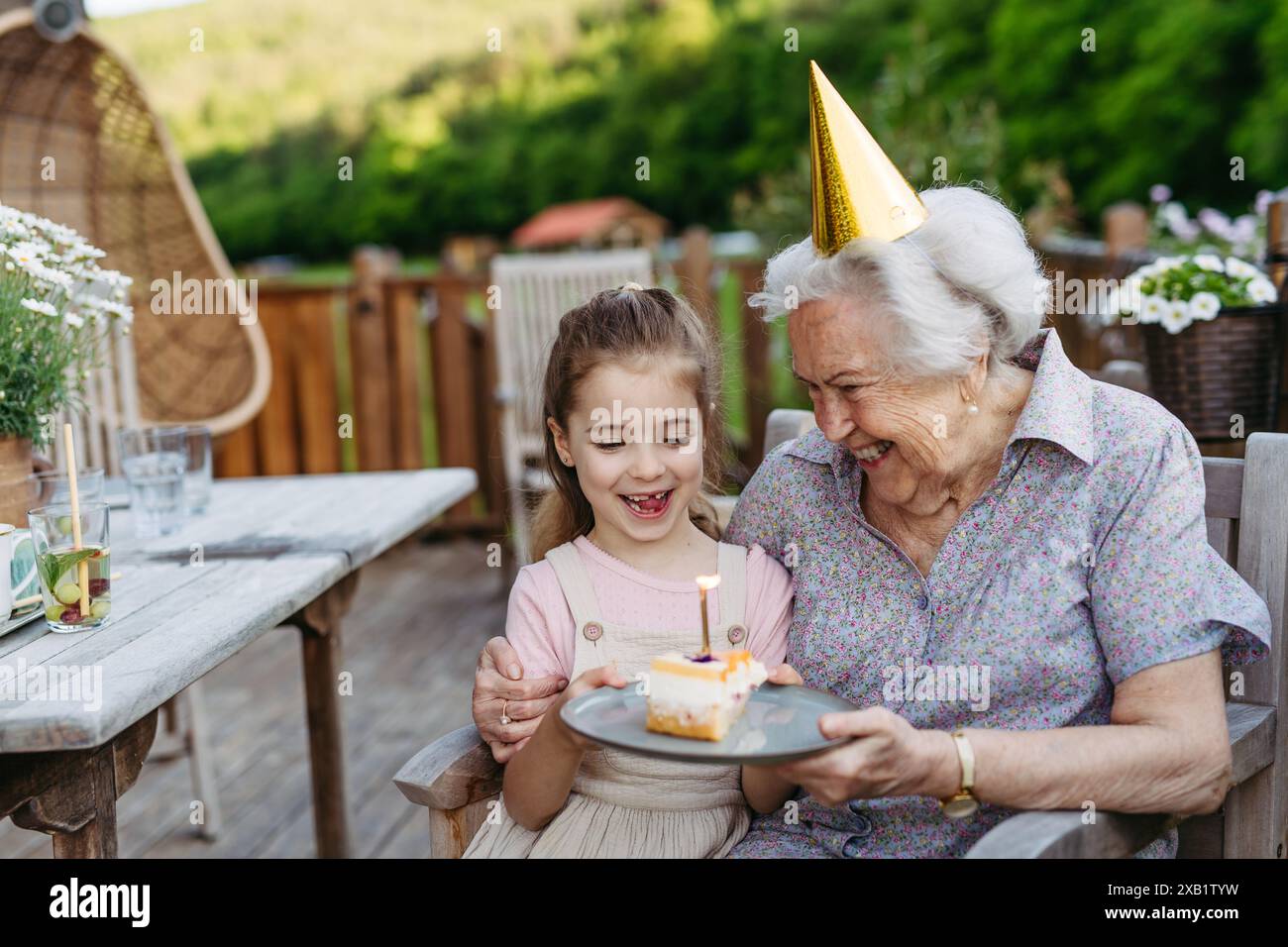 Granddaughter celebrating birthday with elderly grandma, holding cake ...