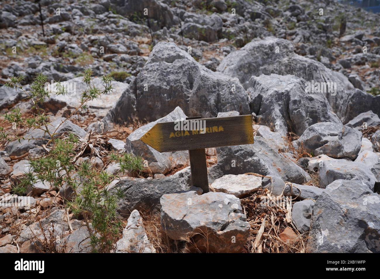 A direction sign on a rocky path in the hills of Pedi, a small fishing ...