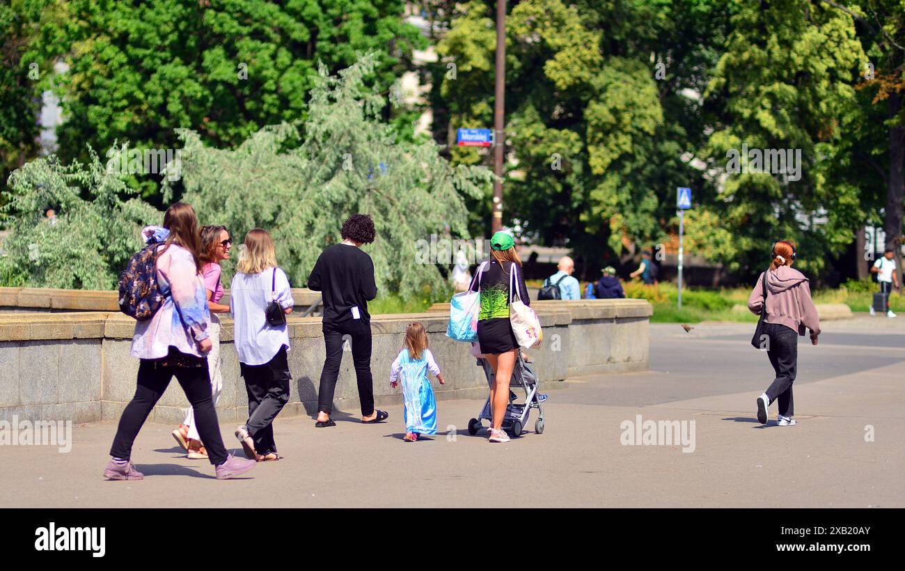 Warsaw, Poland. 8 June 2024. People walking down an urban sidewalk with ...
