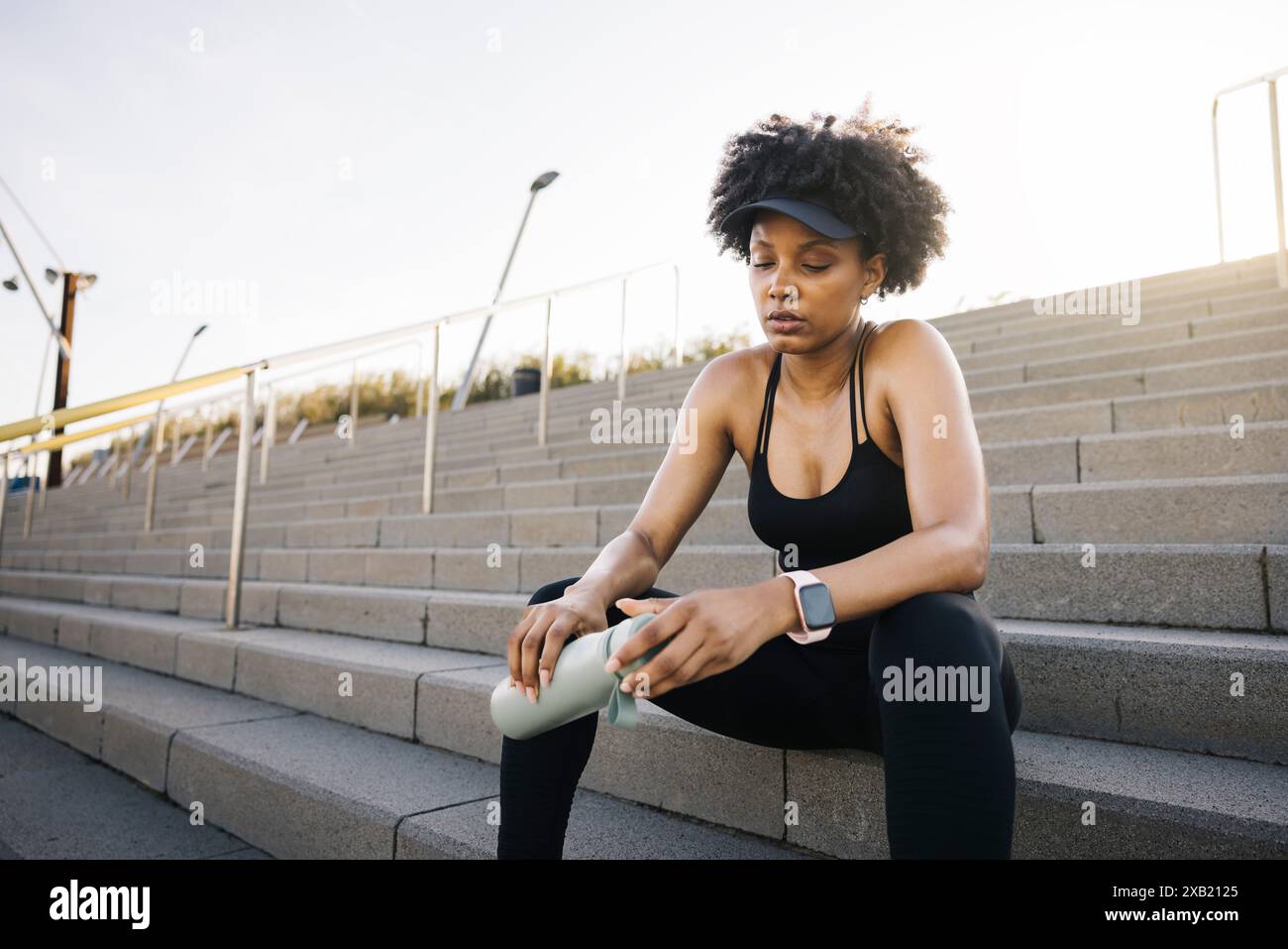 Young tired woman having a break and resting on the steps after a ...