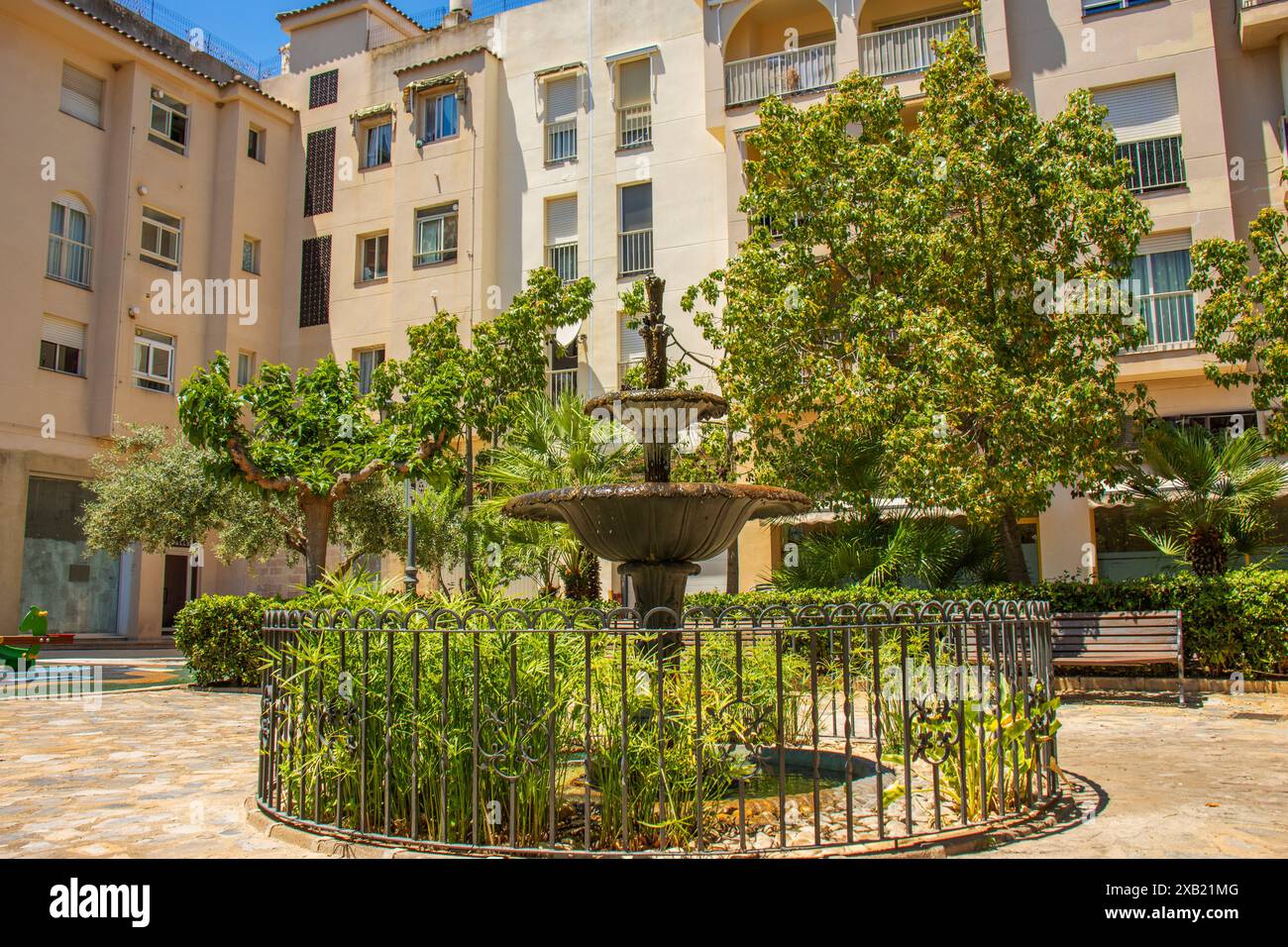 A charming courtyard in Spain with a central fountain, surrounded by ...