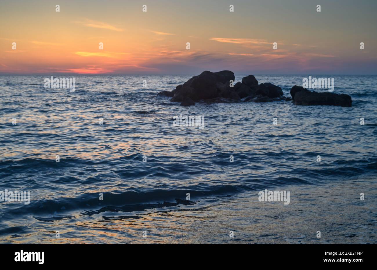 Group of small rock formations and a dramatic sunset sky Stock Photo ...