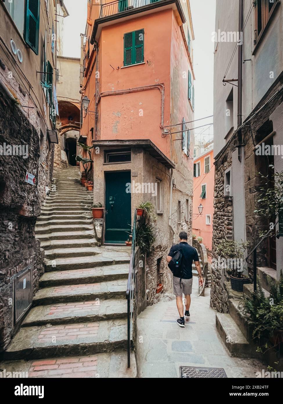 Man walking down narrow colorful street in Vernazza, Italy Stock Photo ...