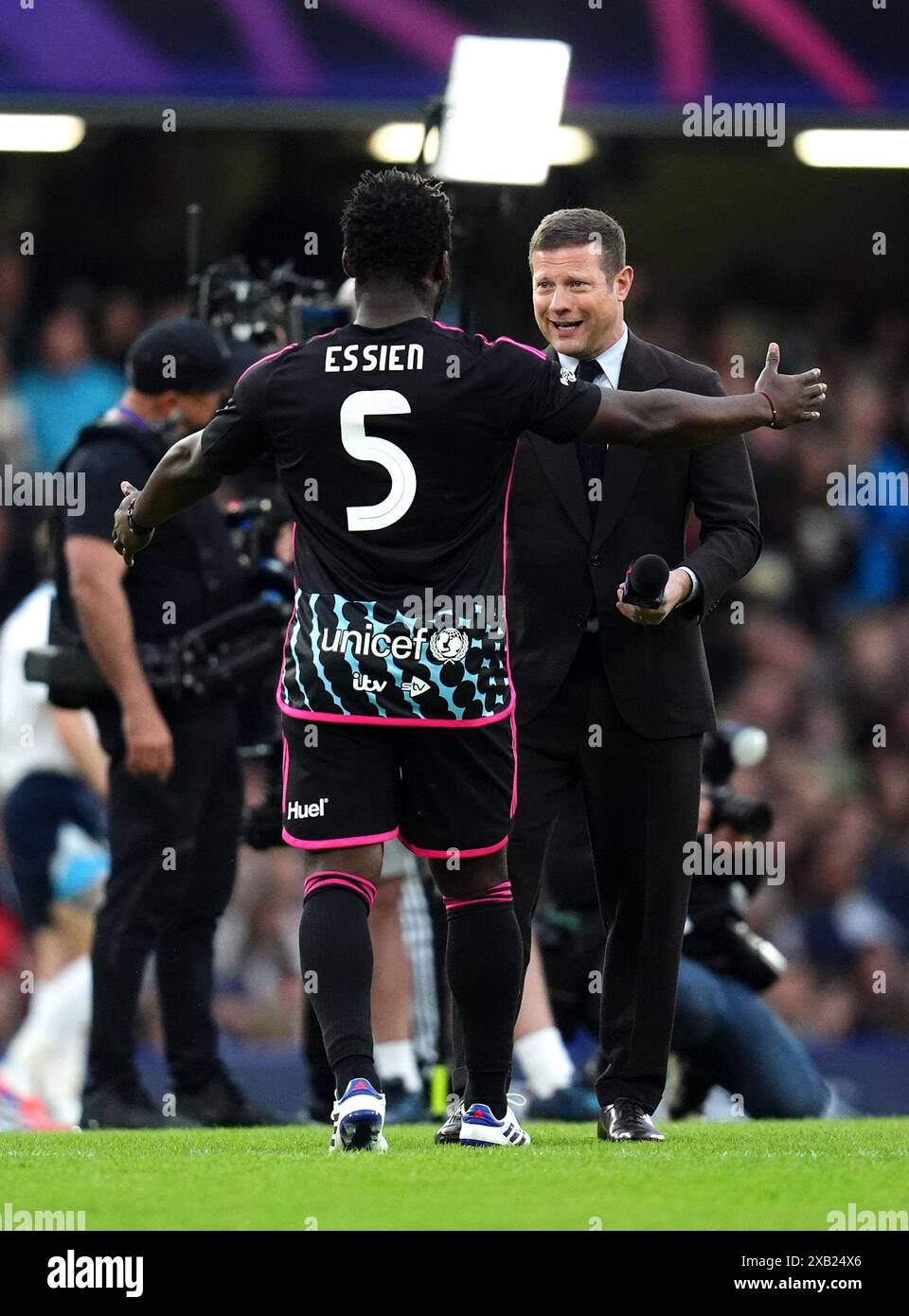World XI's Michael Essien (left) embraces presenter Dermot O'Leary ...