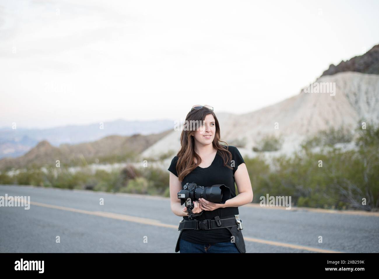 Happy women on street holding camera Stock Photo - Alamy