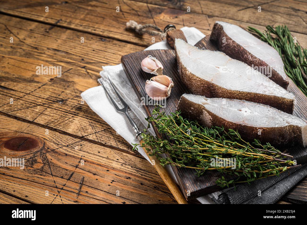 Atlantic halibut fish, raw steaks on wooden board with herbs. Wooden ...