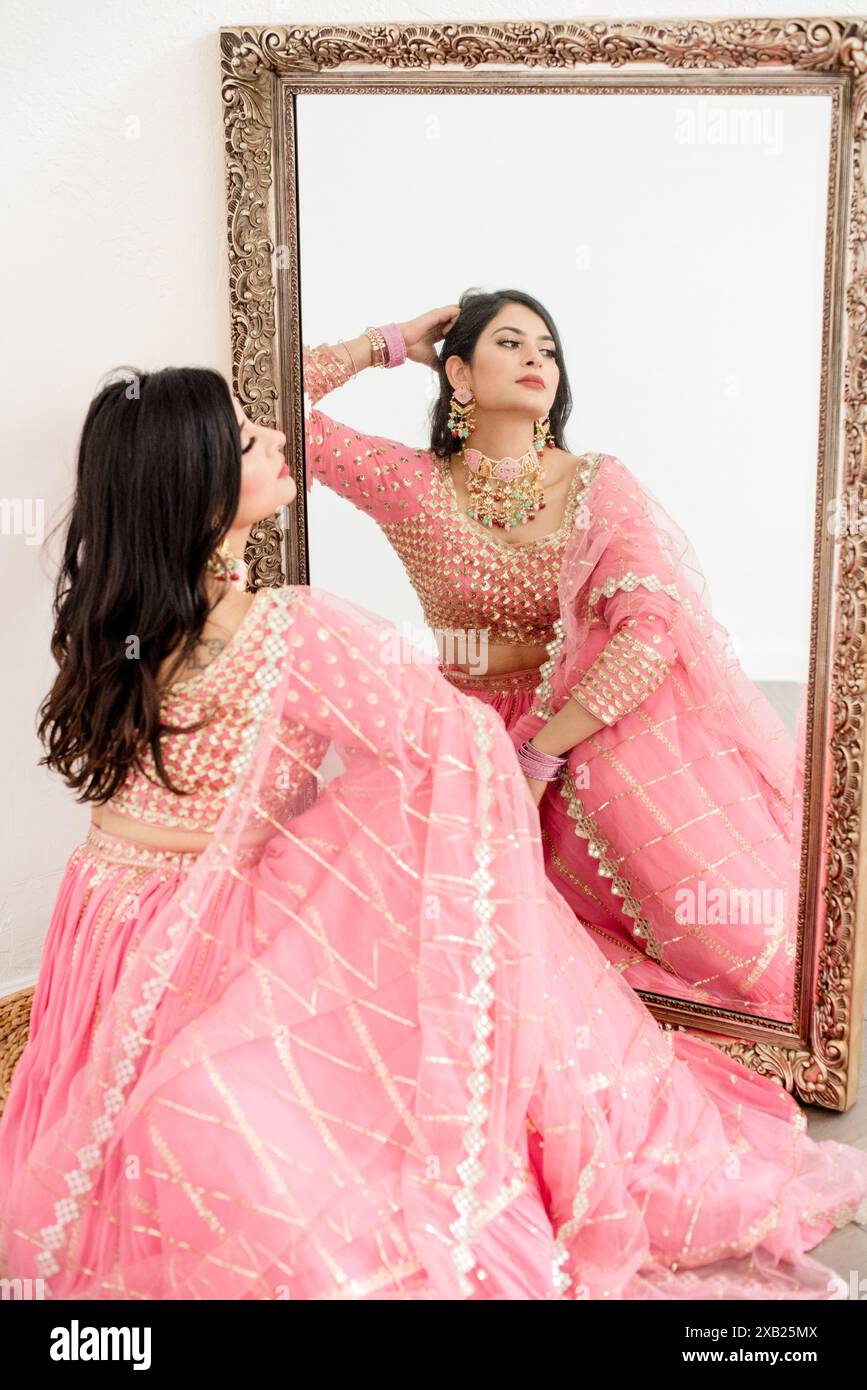 Reflection of Indian women in mirror wearing a pink traditional Stock ...