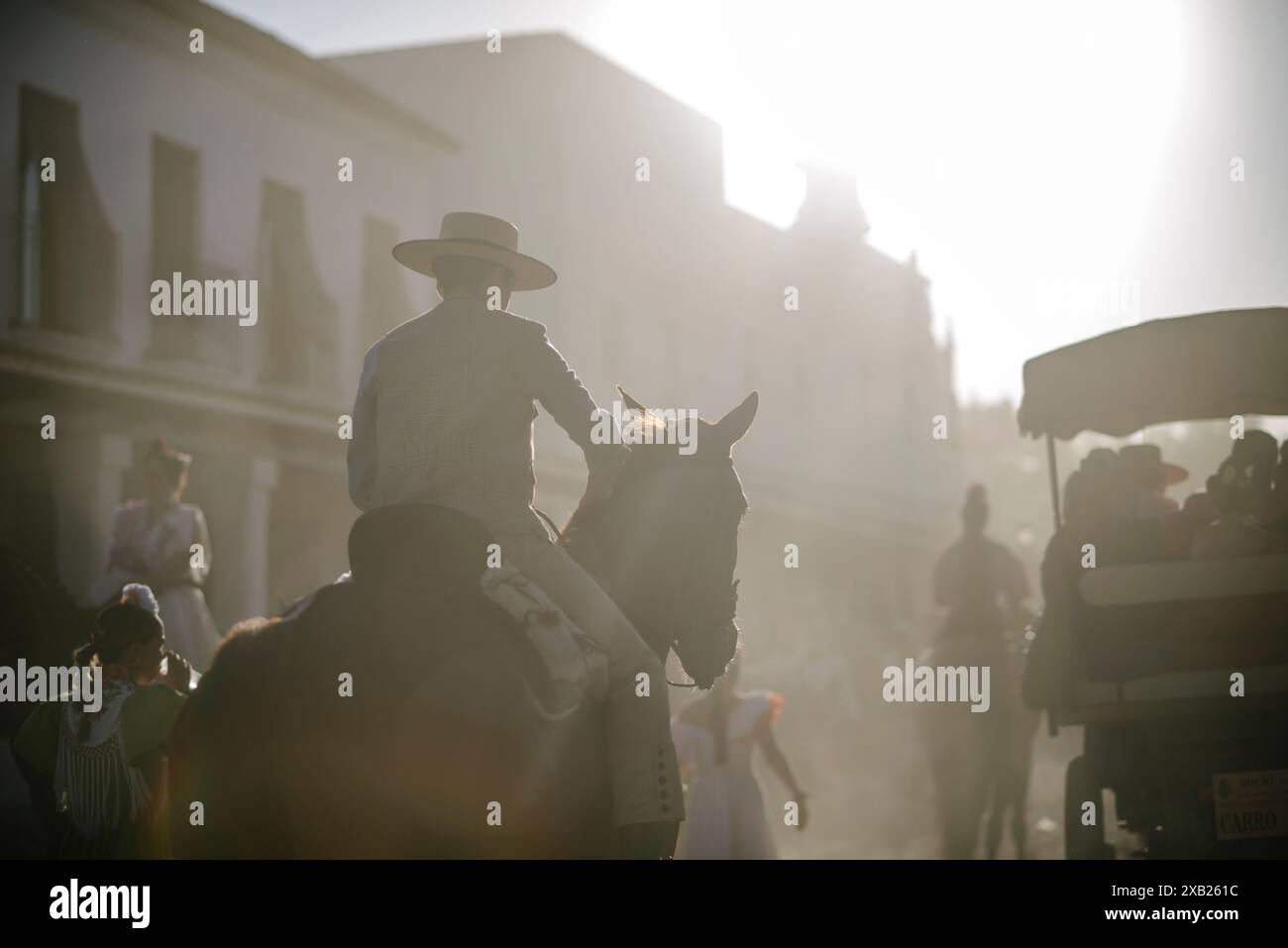 Silhouette of traditional Andalusian cowboy riding through the dust ...
