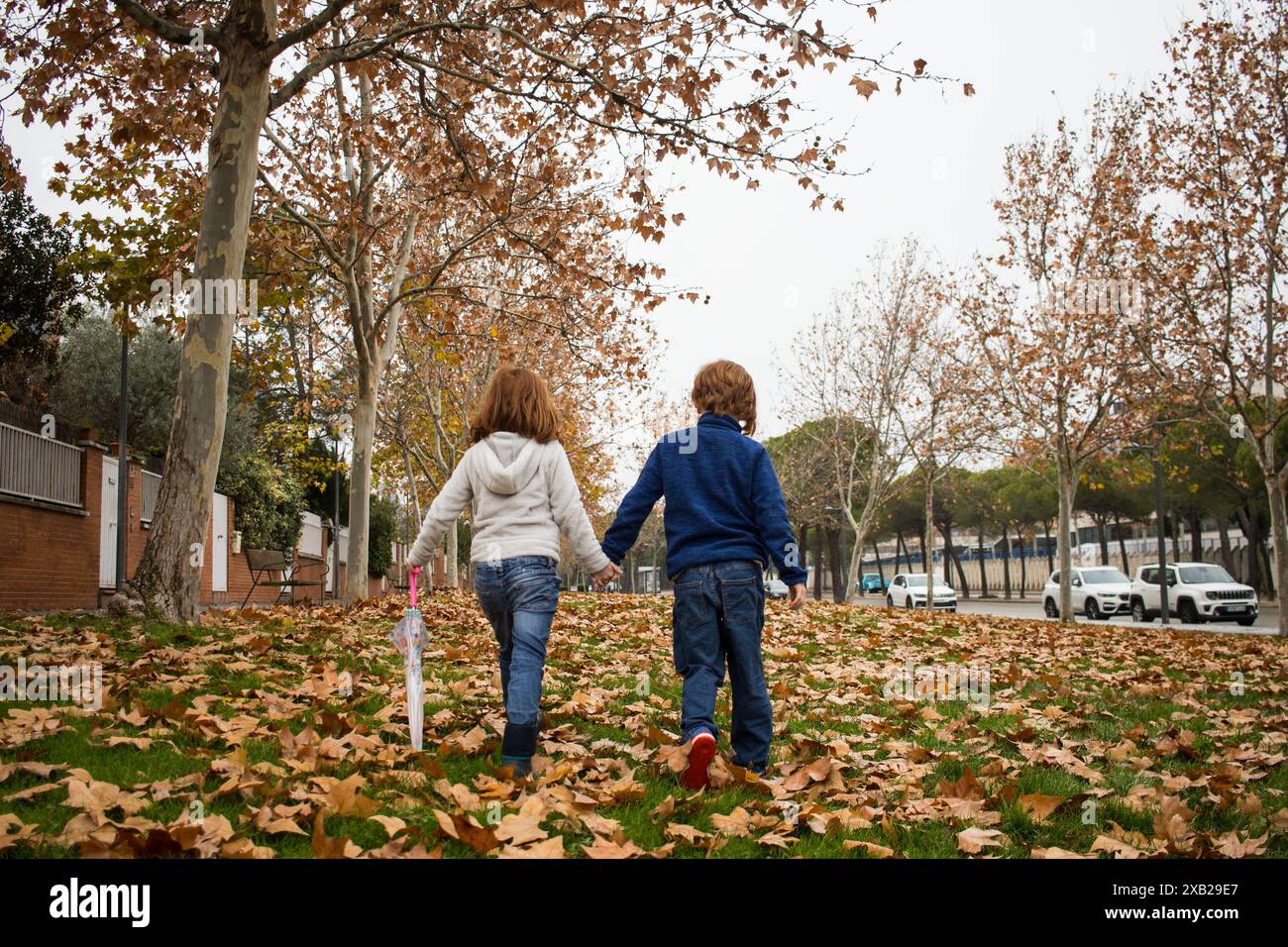 two child sibling walking and talking together friendly outdoors ...