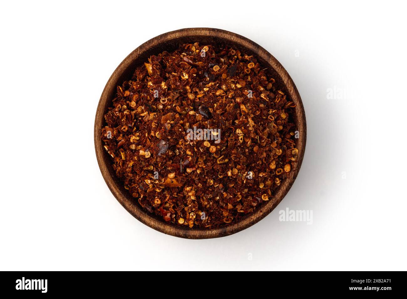 dried chili flakes in a wooden bowl, isolated on white background ...