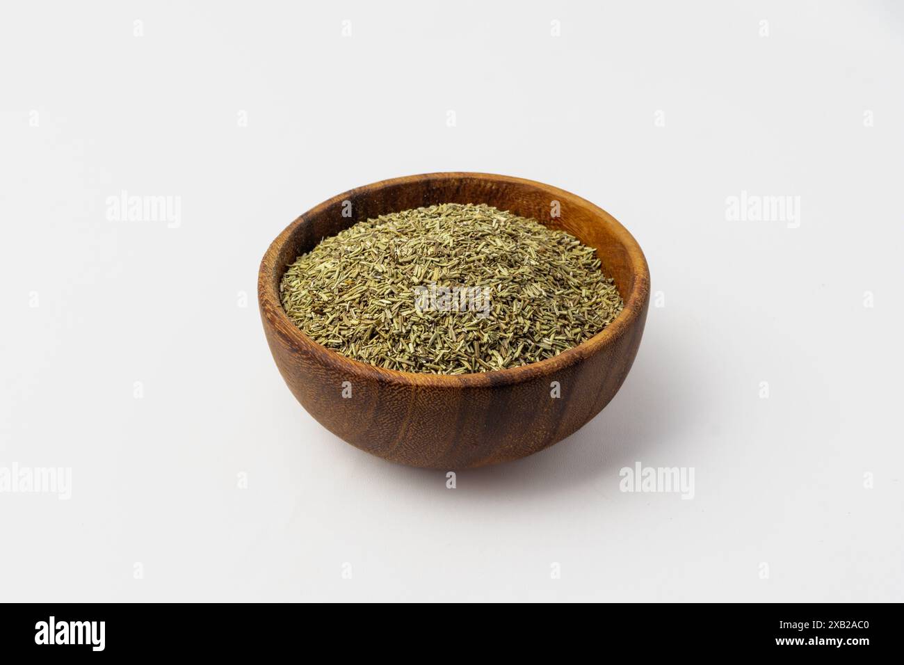 organic dried rosemary in a wooden bowl, isolated on white background ...