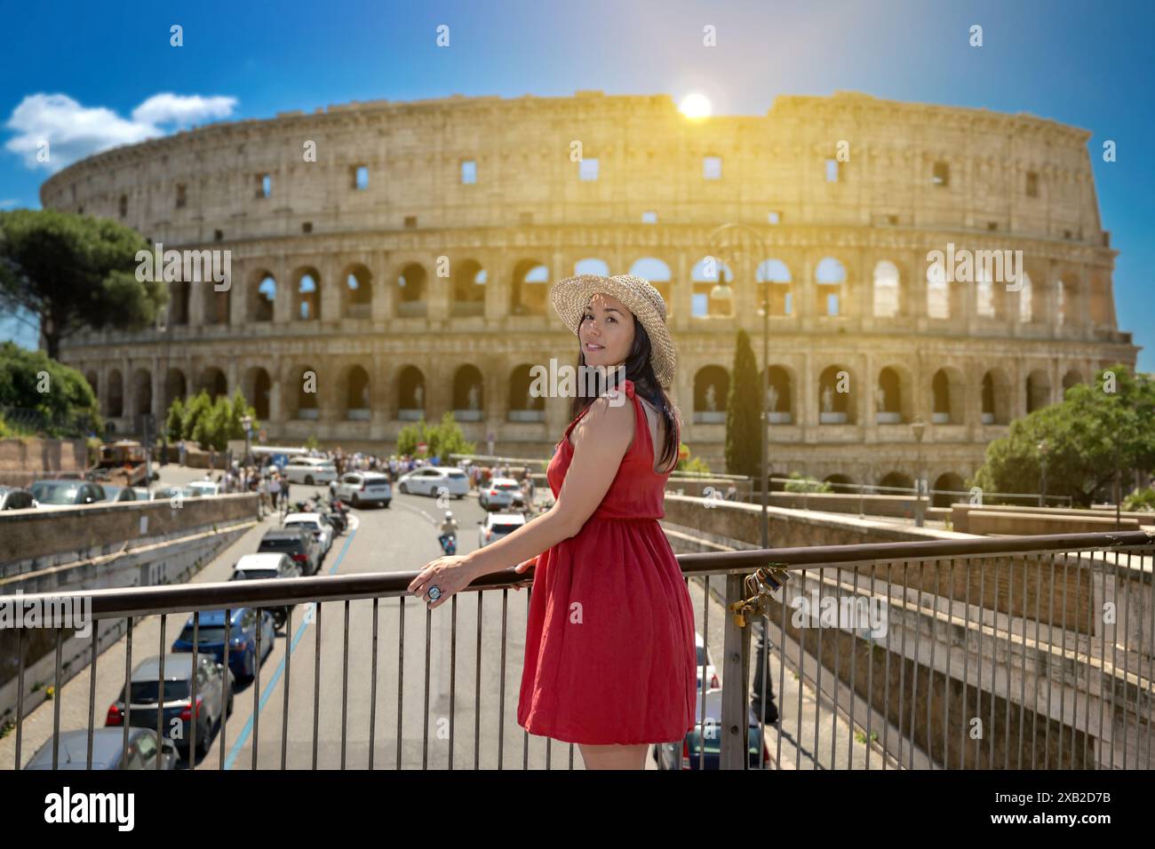 Brunette girl in a straw hat and a red dress admires the ancient ...