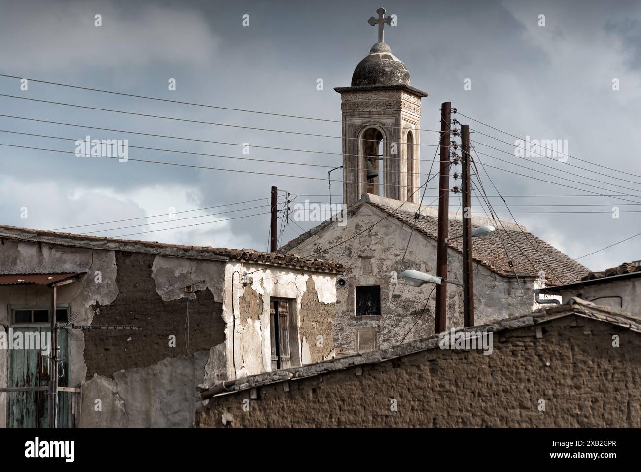Old church tower standing above weathered buildings in a Episkopeio ...