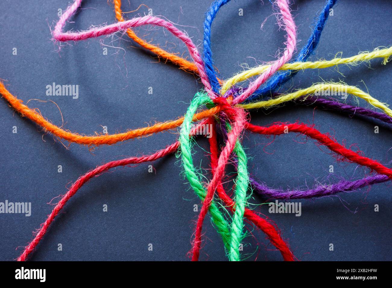 The colored threads are tied together in a knot as an abstract symbol ...