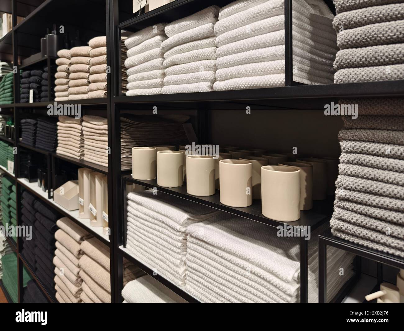 A stack of white towels neatly arranged on a black shelf Stock Photo ...