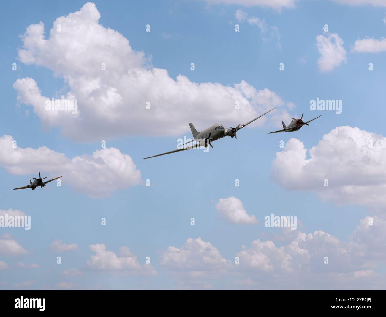 Normandy, France - June 8, 2024: DC3 transport aircraft escorted by a World War II Spitfire P-47 ...