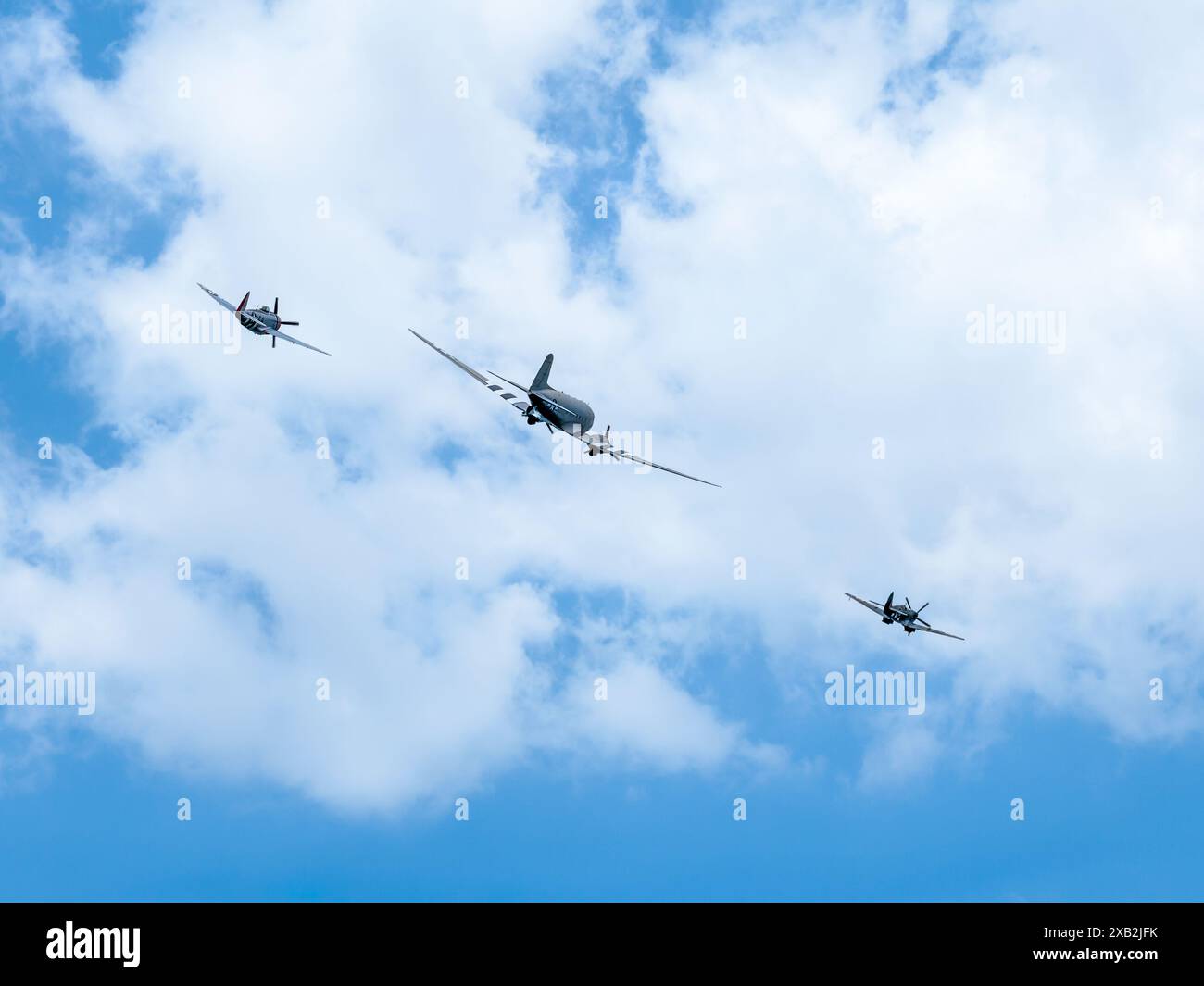 Normandy, France - June 8, 2024: DC3 transport aircraft escorted by a World War II Spitfire P-47 ...