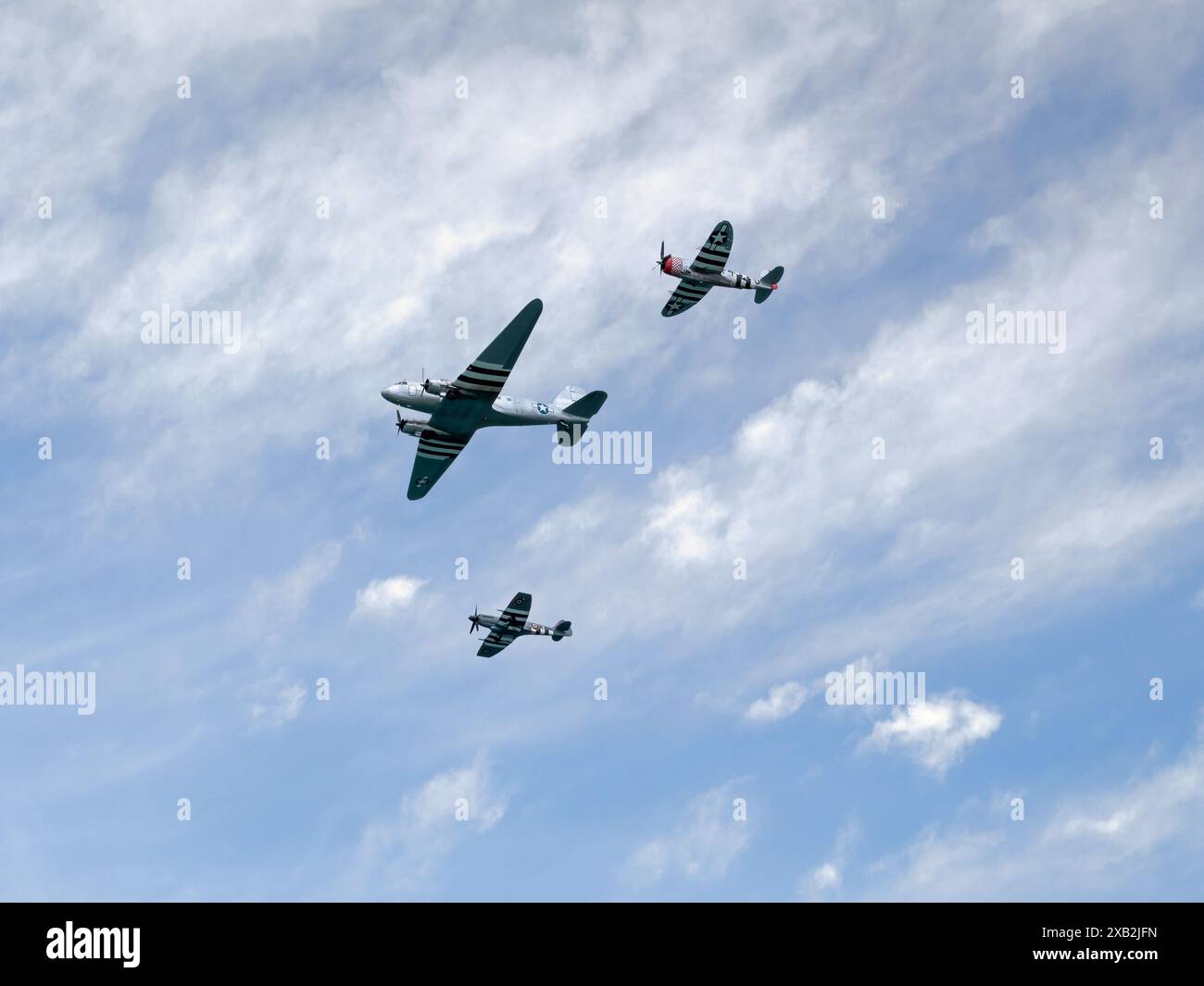 Normandy, France - June 8, 2024: DC3 transport aircraft escorted by a World War II Spitfire P-47 ...