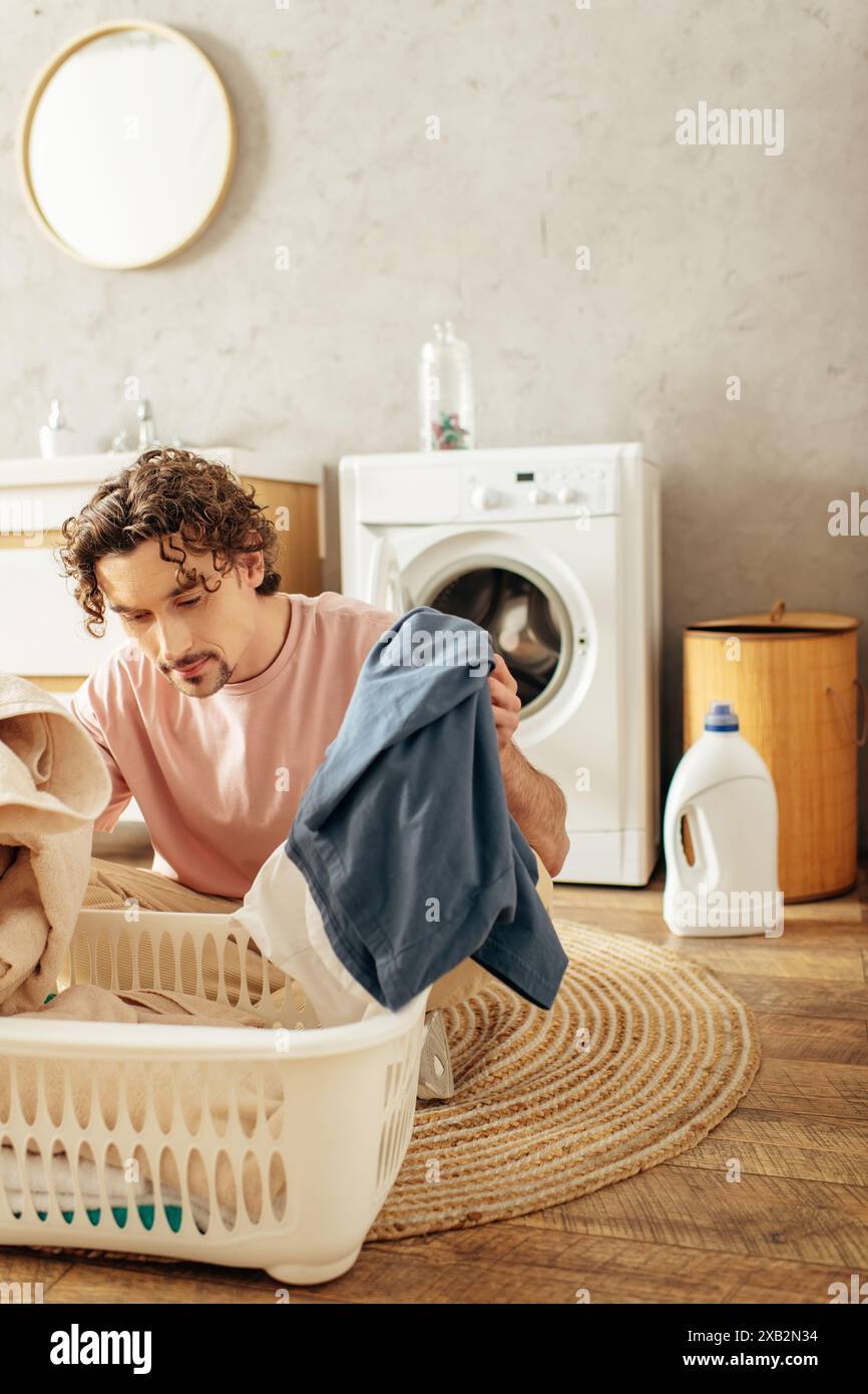 A handsome man in cozy homewear doing laundry in a laundry basket Stock ...
