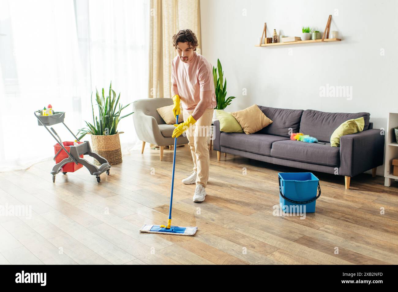 Handsome man in cozy homewear cleaning his living room with a mop Stock ...