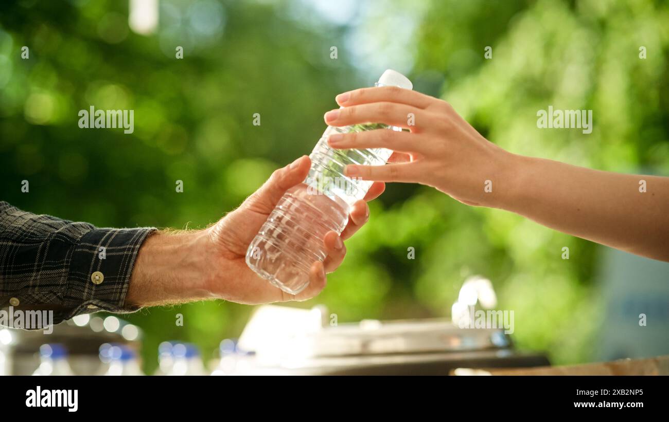 Close Up of a Anonymous Person Handing Over a Water Bottle to Another ...