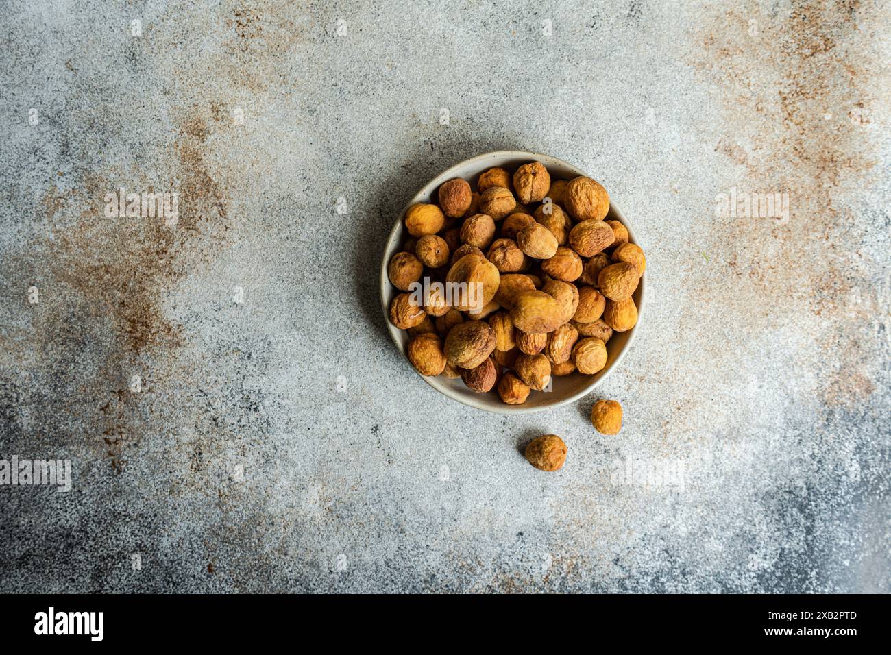 Bowl of sun-dried wild apricots, known as Arashan Kandak, on a textured ...