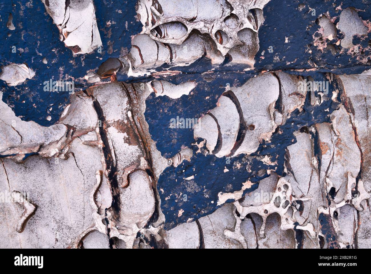 Alveolar erosion on cliff; cold and warm tones conduits excavated in ...