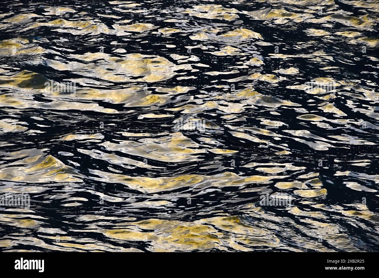 A photo capturing intricate ripples and reflection patterns on a dark ...