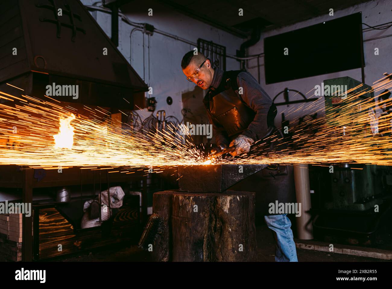 A skilled male blacksmith forges with intense heat, sending sparks ...
