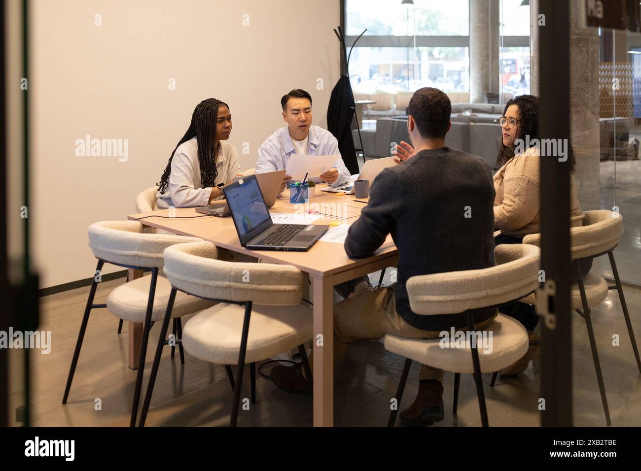 Diverse group of young professionals engaged in a meeting at a modern ...